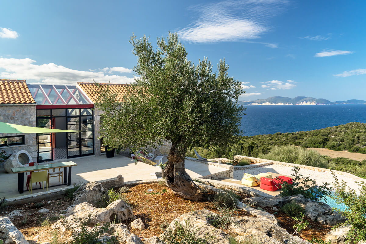 Une maison grecque en pierres et verre avec vue sur la mer