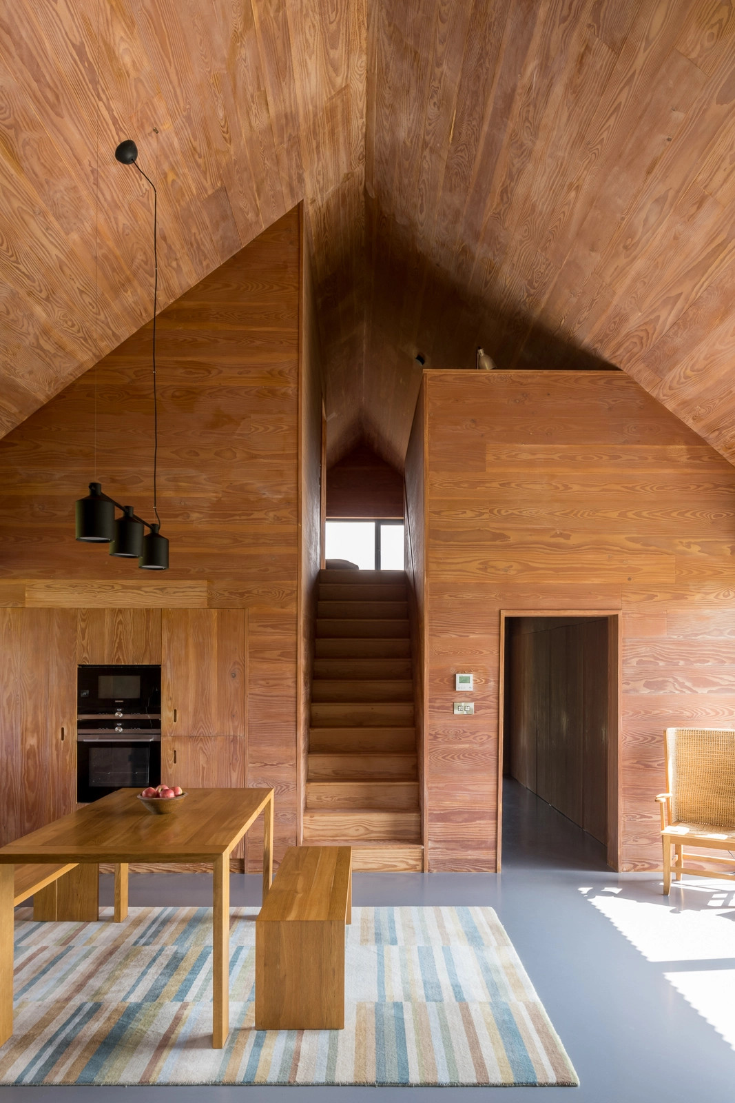 Une maison en aluminium noir et son studio près d'un loch