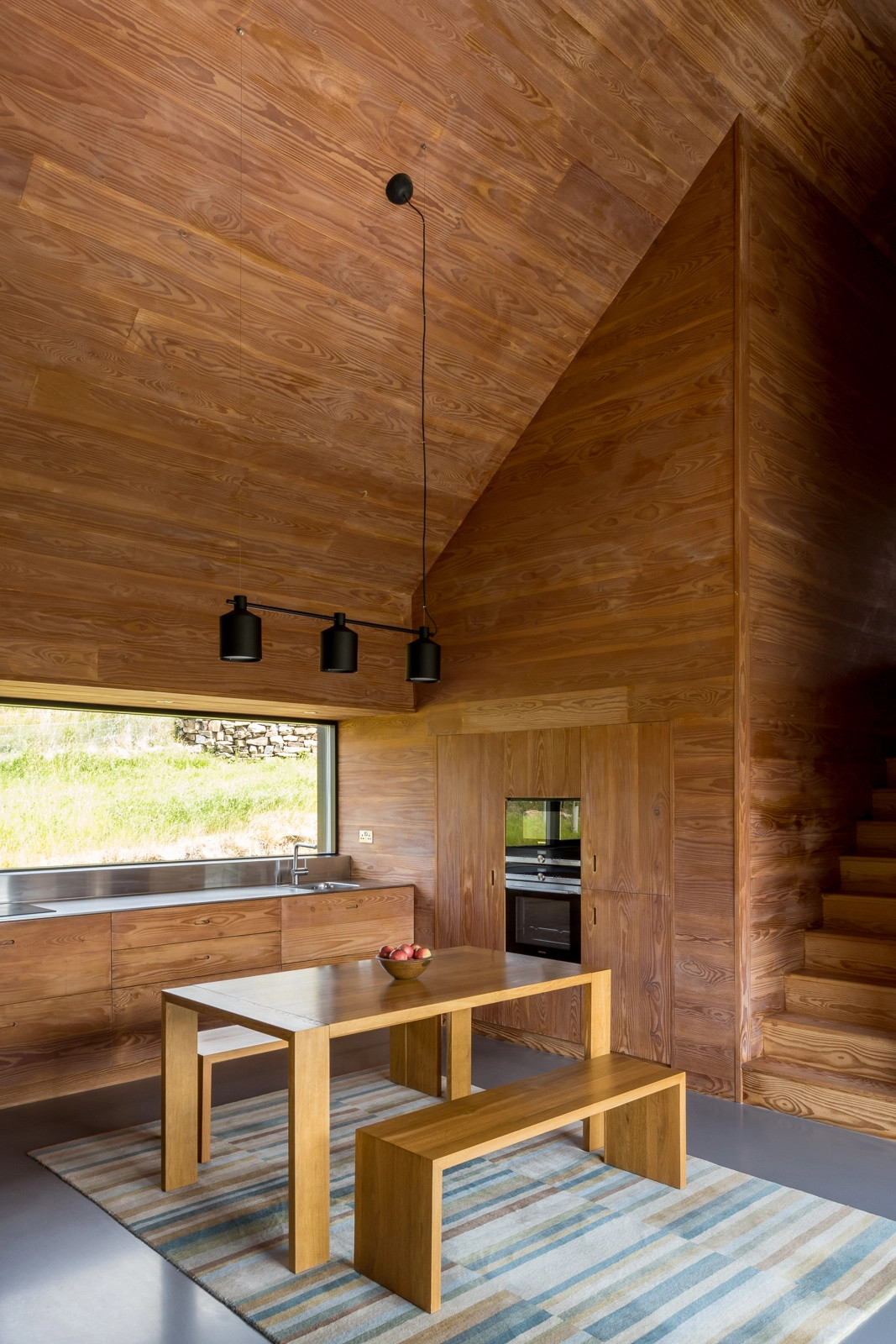 Une maison en aluminium noir et son studio près d'un loch