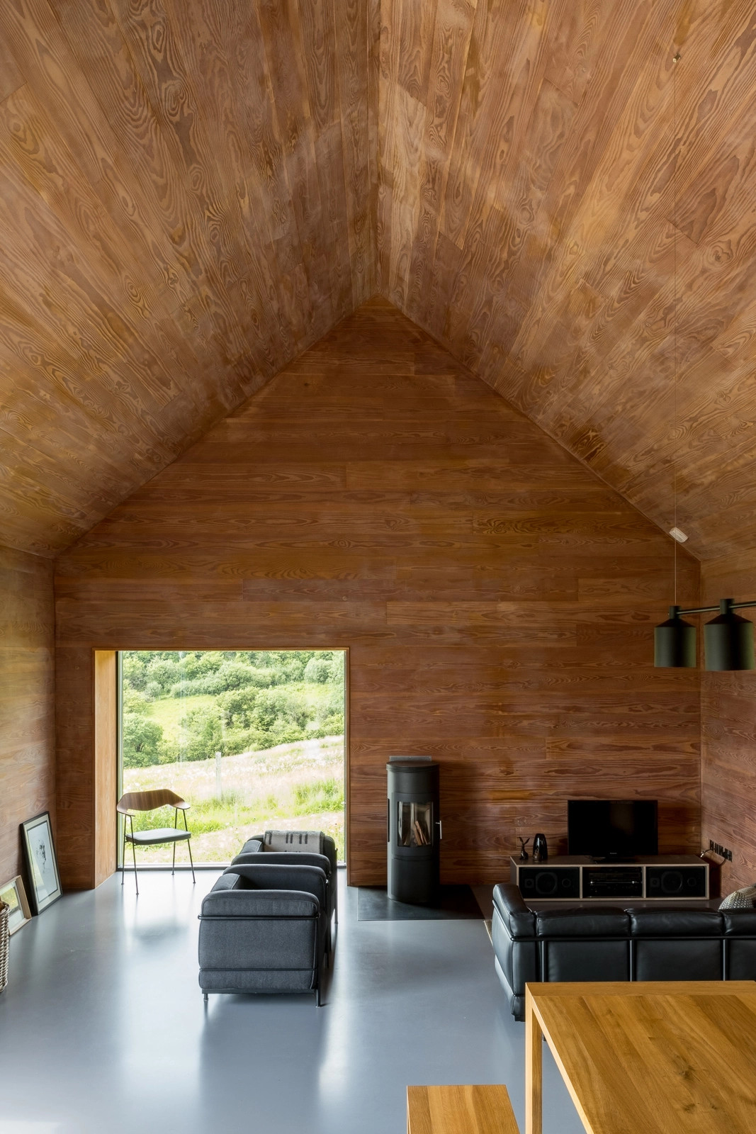 Une maison en aluminium noir et son studio près d'un loch