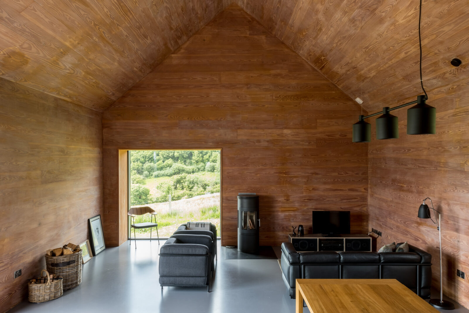 Une maison en aluminium noir et son studio près d'un loch