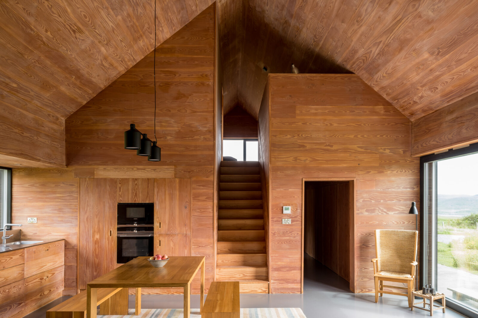 Une maison en aluminium noir et son studio près d'un loch