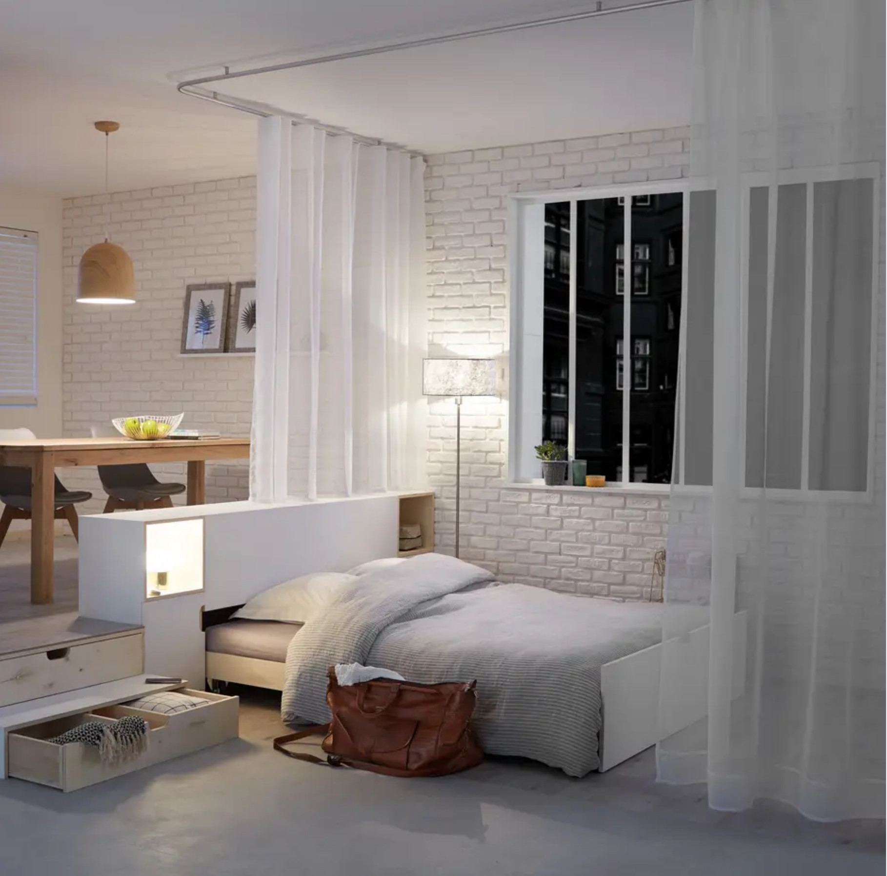 Un lit caché sous une estrade dans le salon d'un studio