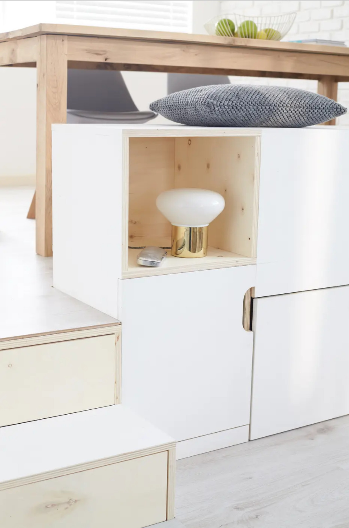 Un lit caché sous une estrade dans le salon d'un studio