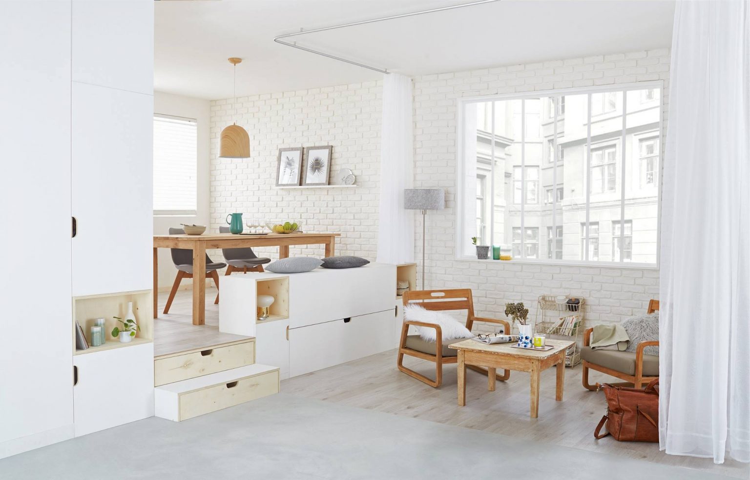 Un lit caché sous une estrade dans le salon d'un studio