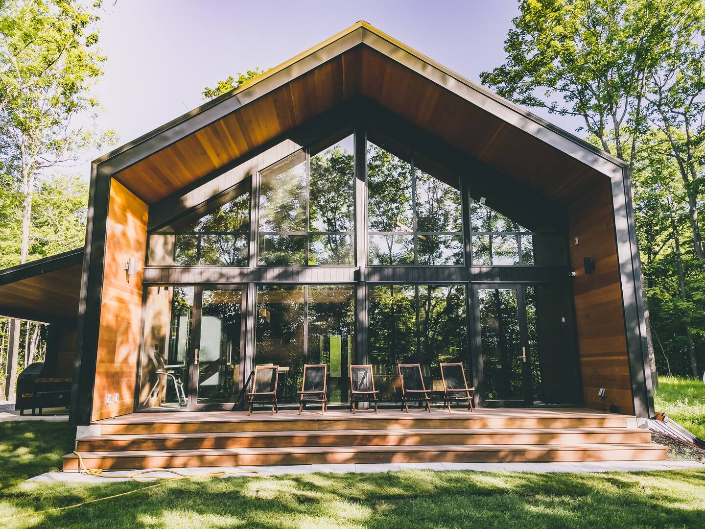 Une maison noire moderne et épurée avec un pignon vitré en Ontario