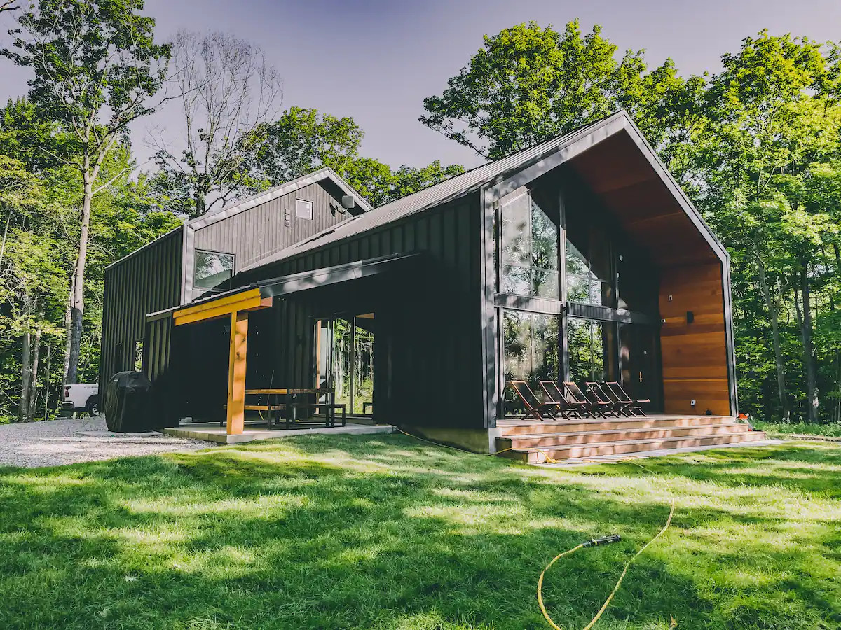 Une maison noire moderne et épurée avec un pignon vitré en Ontario